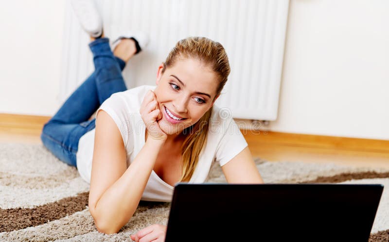 Focused Young Woman Using Laptop while Lying on Floor Stock Photo ...