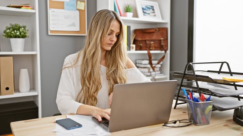 Focused Young Woman Working on Laptop in a Modern Home Office Interior ...