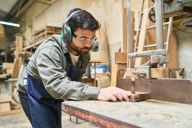 Focused Young Worker Using a Saw in a Lumberyard Workshop Stock Photo ...