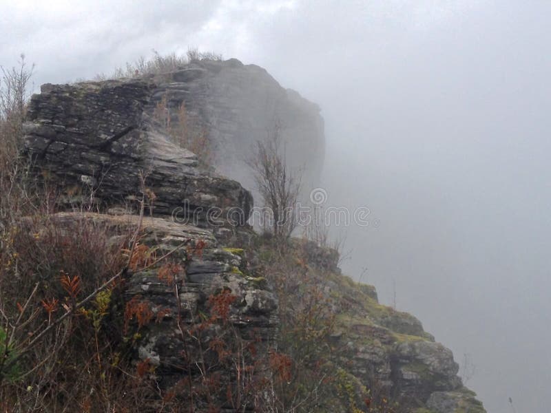 Fog Rolling Over Cliff Edge Stock Photo - Image of clouds, precipice ...
