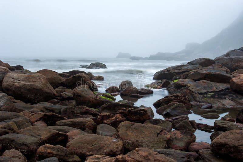 Foggy Beach with Rocks and Mist at Nightfall Stock Image - Image of ...