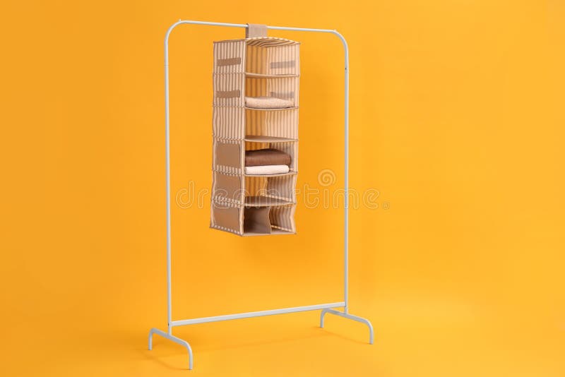 Foldable Organizer on Rack Against Yellow Background Stock Image ...