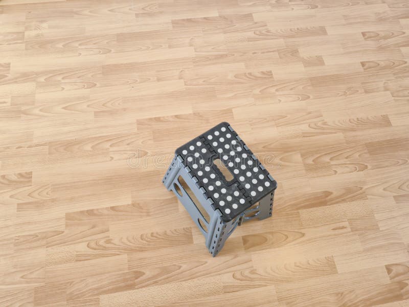 A Foldable Step Stool with a Dotted Surface Sits on a Wooden Floor ...