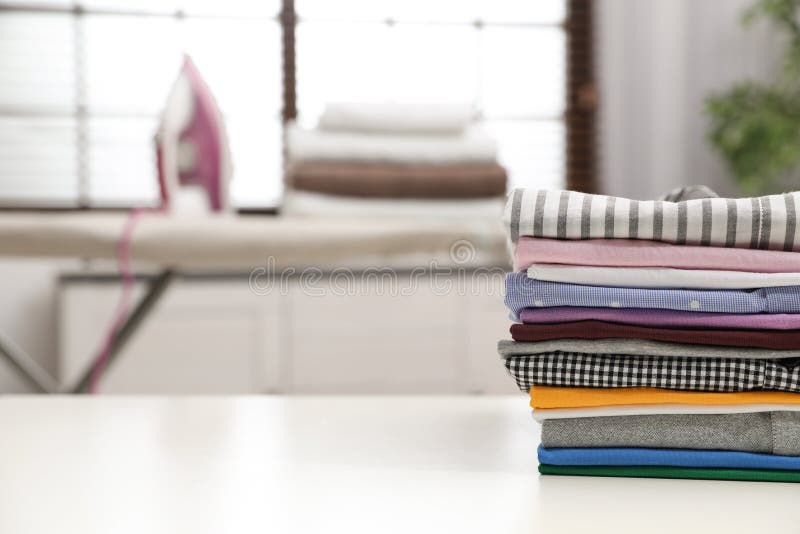 Folded Clean Clothes on Table Indoors. Laundry Day Stock Image - Image ...