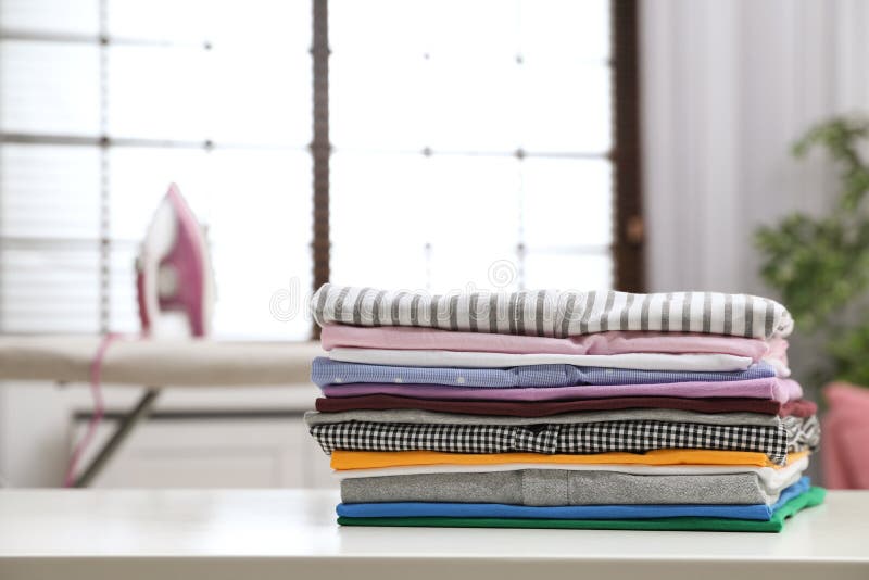 Folded Clean Clothes on Table Indoors. Laundry Day Stock Image - Image ...