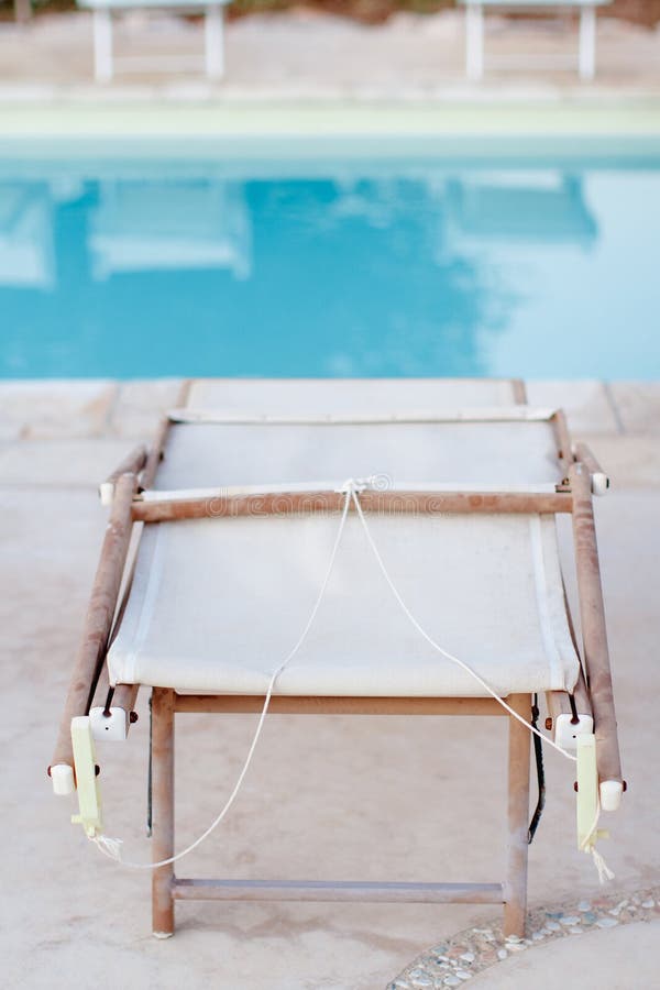 Folded Deck Chairs Near a Swimming Pool in a Garden Stock Image - Image ...