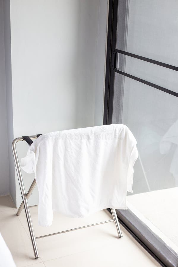 Folding Drying Rack with White Towel in Room with Large Window and ...