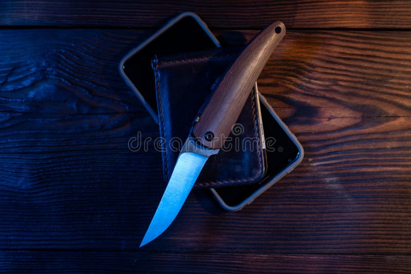 Folding Pocket Knife and Wallet on the Table. a Sharp Knife with a ...