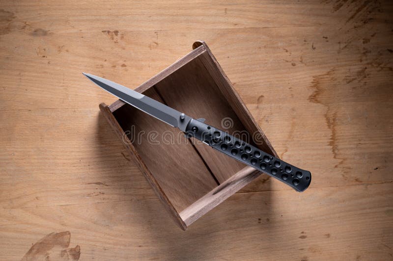Folding Sharp Knife on an Old Table. Knife with Black Handle on the Box ...
