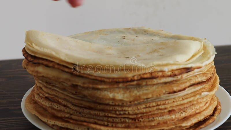 Folding Thin Crepe from Tall Stack into Triangle Shape Over White Plate ...