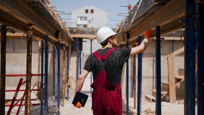 Following Back Shot of Professional Construction Worker in Hard Hat ...