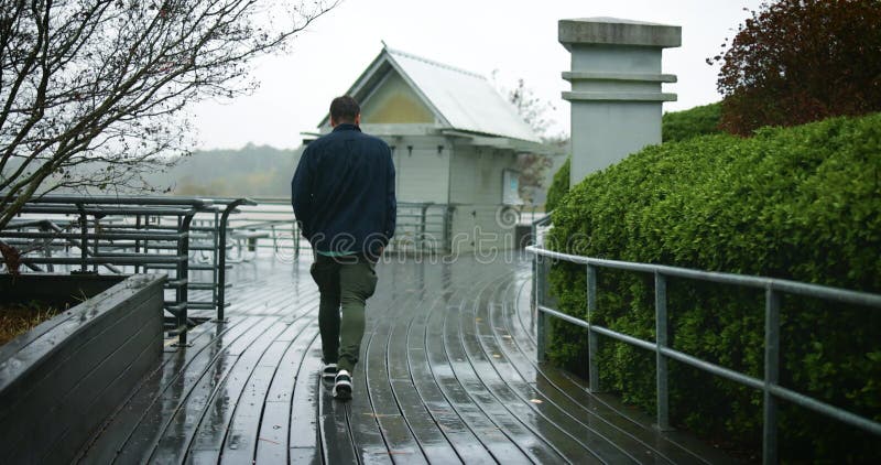 Following the Man Walking Under the Rain on Cold Day Stock Footage ...
