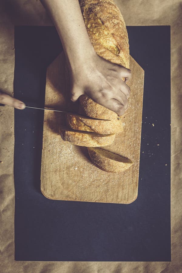 Food Concept. Hand Cutting Bread. Slicing a Bread Stock Photo - Image ...