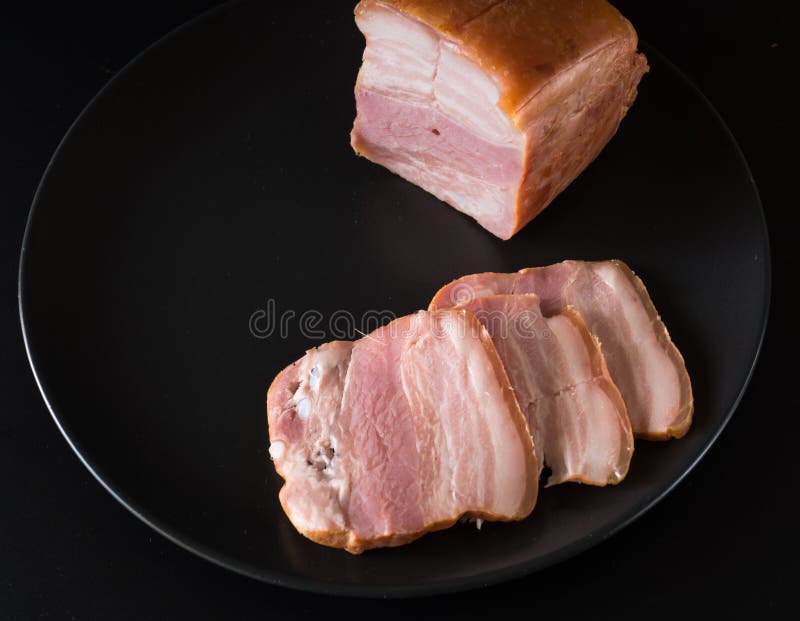 Food, a Piece of Bacon and Cut into Slices, on a Black Plate on a Black ...