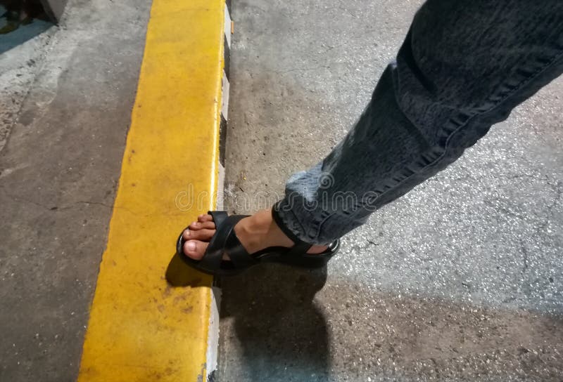 Foot Stepping on Yellow Lane Stock Photo - Image of yellow, gray: 119084734