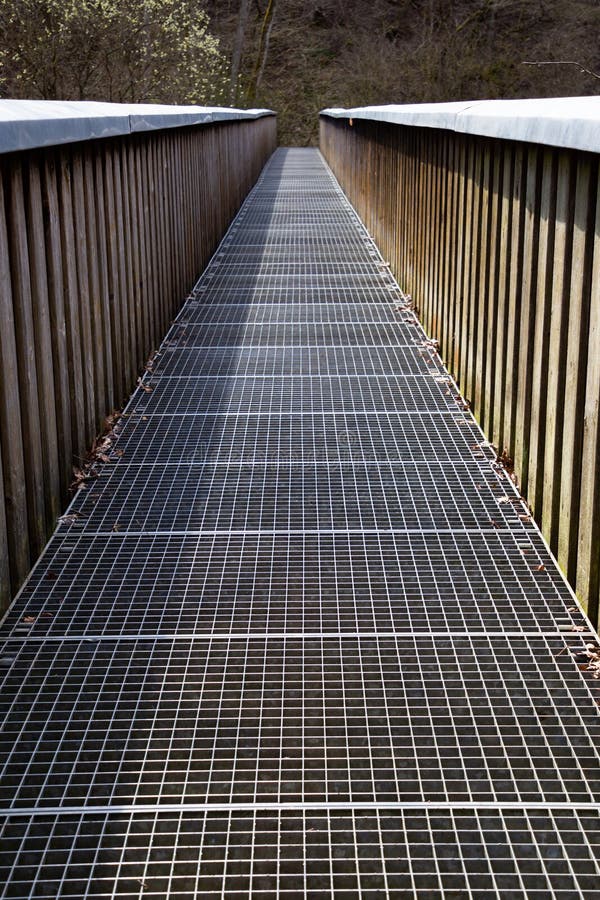 Footbridge with Iron Grating Floor and Wooden Railing Crossing a River ...