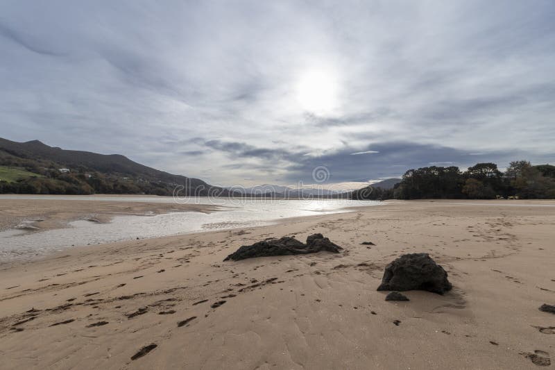 Footprints Covering Sandy Beach at Low Tide with Mountains and Cloudy ...