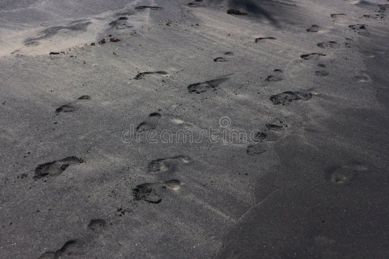 Footsteps on black sand stock photo. Image of footsteps - 274084748