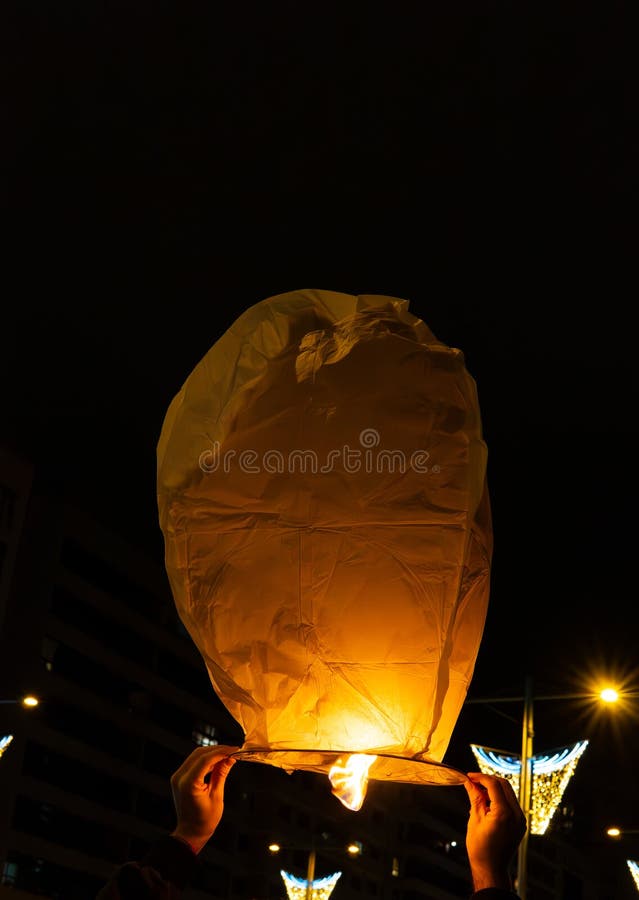 Foreground, Human Hands Release a Chinese Lantern of Light into the ...