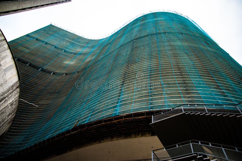 A Building Being Built Next To a Green Tarp Covered Wall Editorial ...