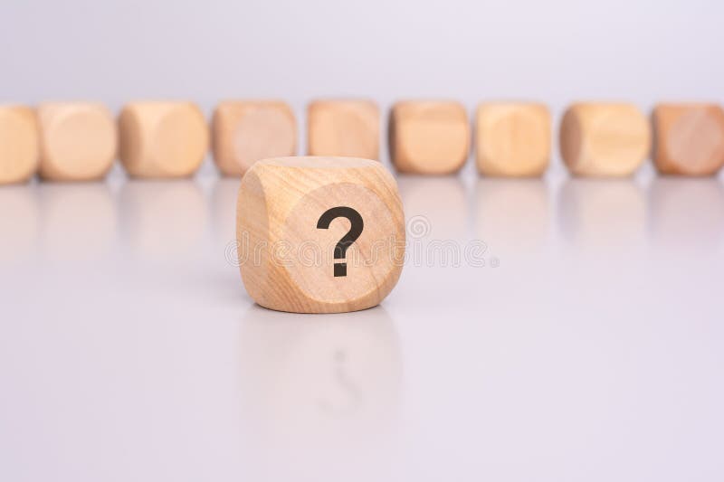 In the Foreground is One Wooden Cube with a Question Mark and a ...