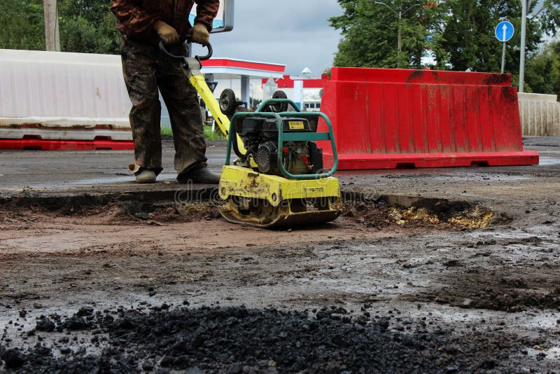 The Foreman of the Construction Team Works with a Vibrating Platform ...