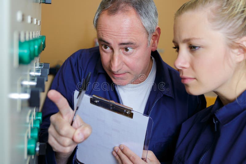 Foreman Explaining Machinery Controls To Female Apprentice Stock Photo ...