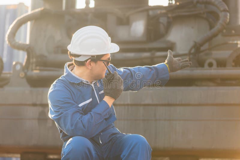Foreman in Hardhat and Safety Vest Talks on Two-way Radio Control ...