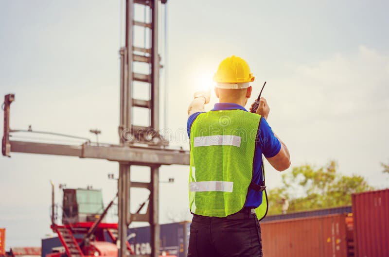 Foreman in Hardhat and Safety Vest Talks on Two-way Radio Control ...