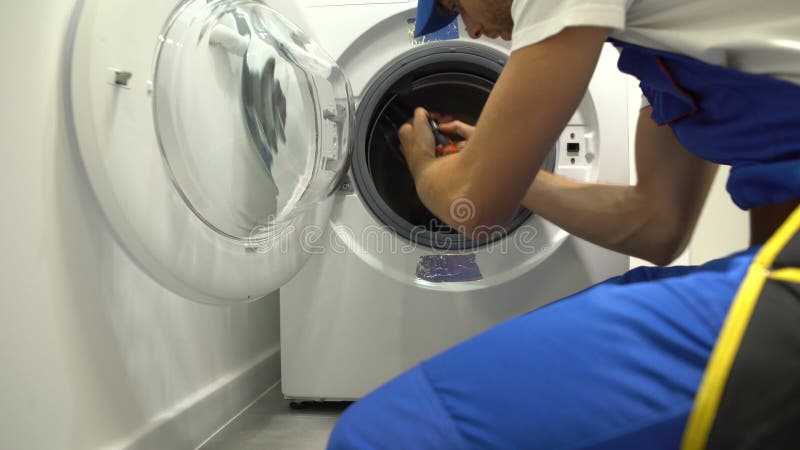 Foreman in Uniform Repairing Washing Machine Using Screwdriver ...
