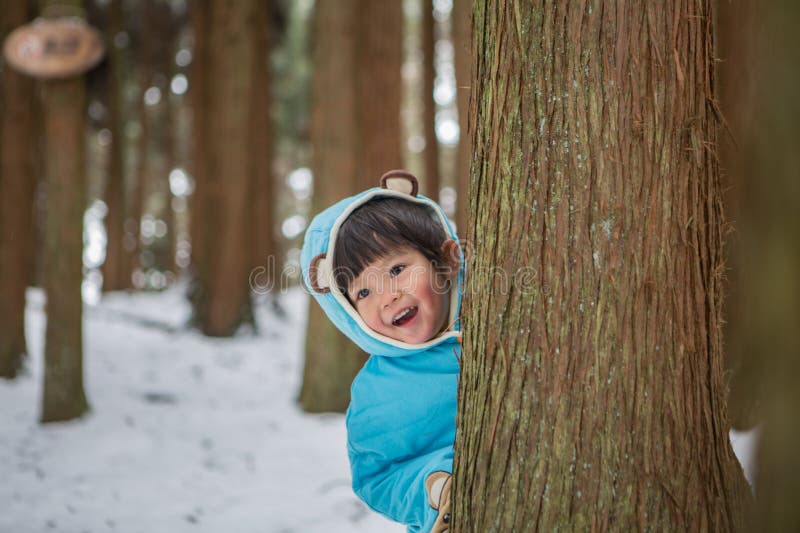 In the Forest after the Snow, the Child Hides Behind the Tree and ...