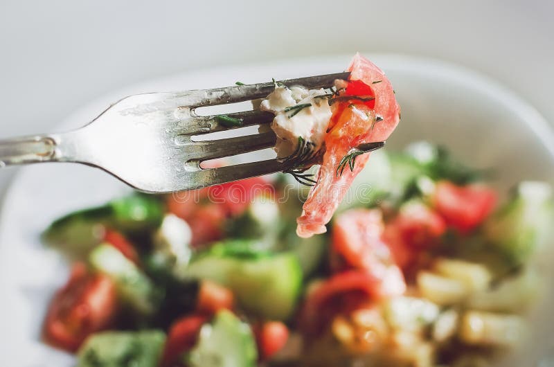 Fork with a Piece of Tomato and Cheese. Greek Salad Stock Photo - Image ...