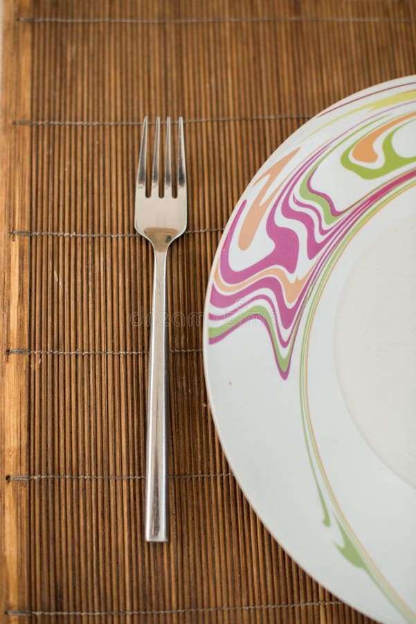 Fork and Plate on Bamboo Mat Stock Photo - Image of swirls, colors ...