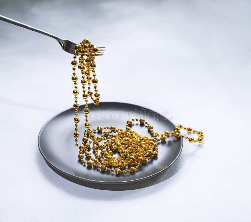 A Fork with a String of Decorative Beads in a Dark Plate on a Light ...