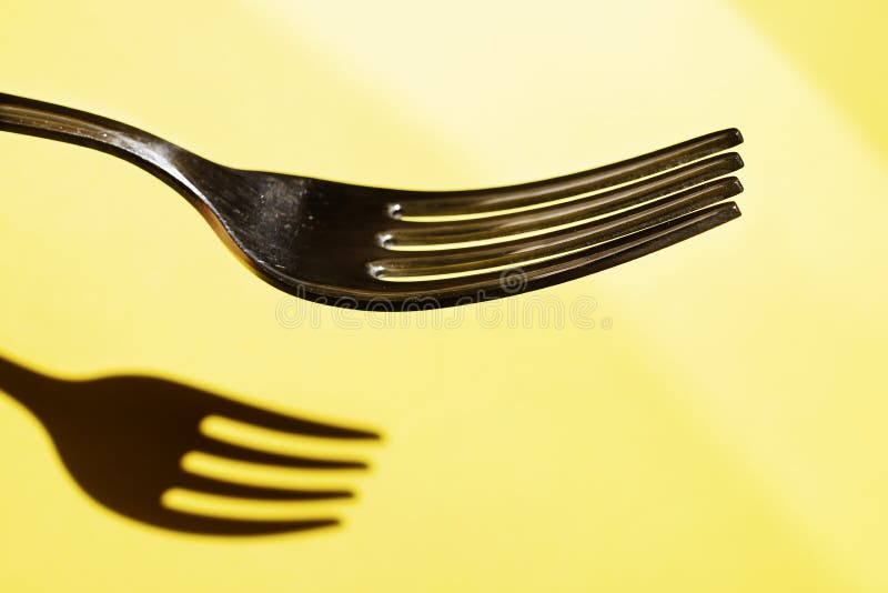 Fork on yellow background stock photo. Image of metallic - 160661984