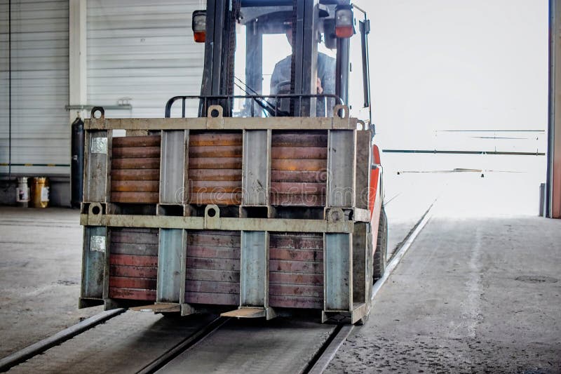 A Forklift Transports a Heavy Load of Metal Weights in an Industrial ...