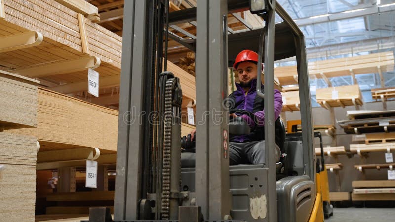 Forklift Driver in Protective Vest Driving Forklift at Lumber Warehouse ...