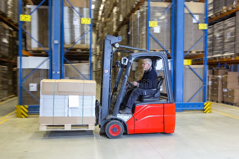 Forklift Driving Alongside a Storage Rack. Stock Image - Image of ...