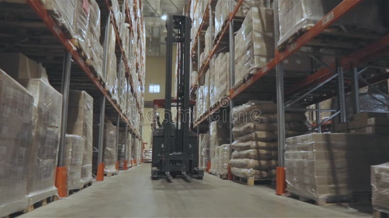 Moving through a Modern Warehouse. a Forklift is Driving through a ...