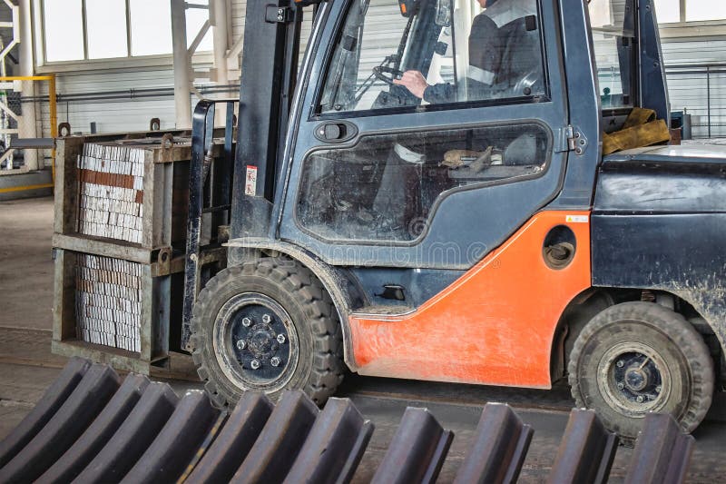 A Forklift Operator Lifts a Heavy Load Inside an Industrial Workshop ...
