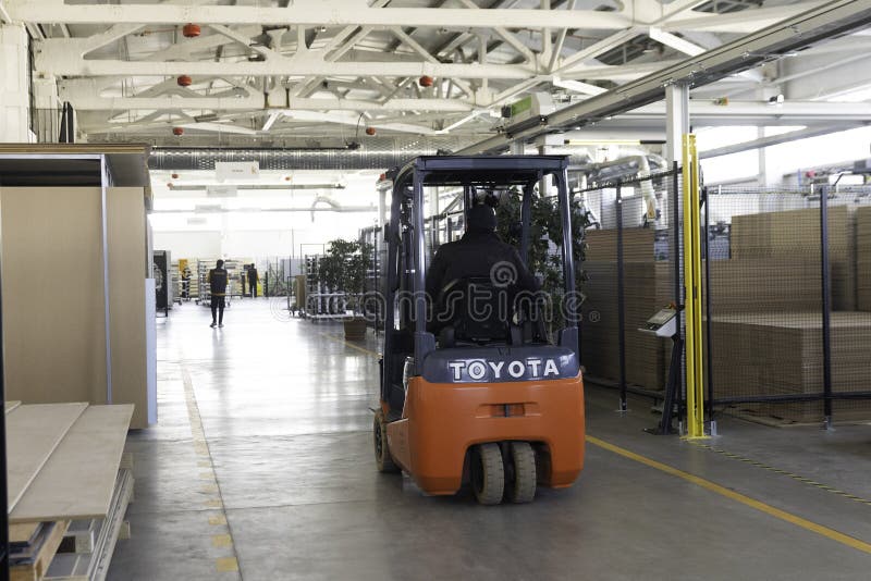 Forklift Operator Transporting Goods in a Busy Warehouse during ...