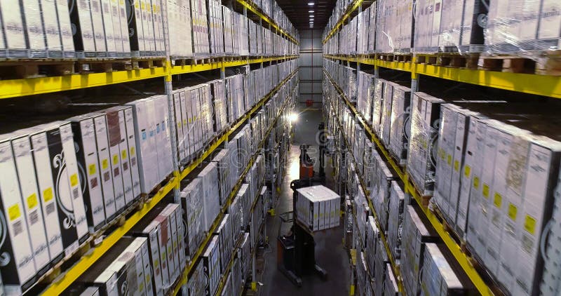 Forklift Puts the Load on the Shelf in the Warehouse. Work Forklifts in ...
