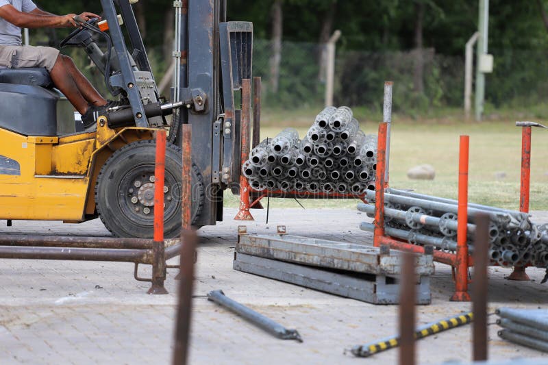 Forklift Transporting Construction Materials at a Building Site in ...