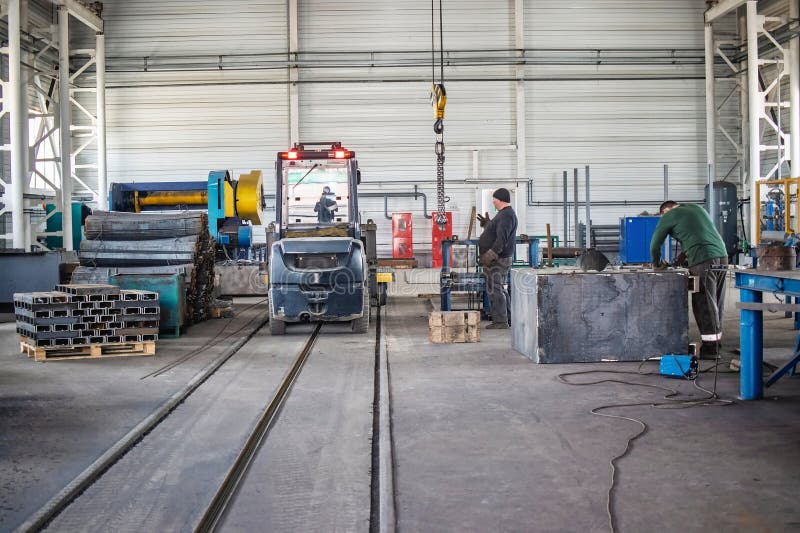Forklift Transporting Heavy Materials in an Industrial Workshop during ...