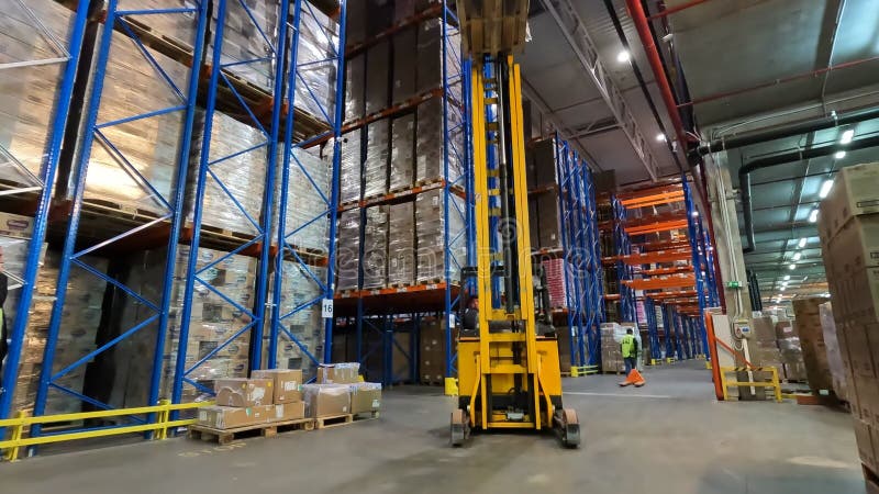 Active Work in the Warehouse. Modern Forklift Works in a Warehouse ...