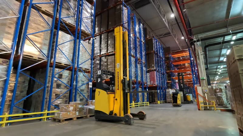Active Work in the Warehouse. Modern Forklift Works in a Warehouse ...