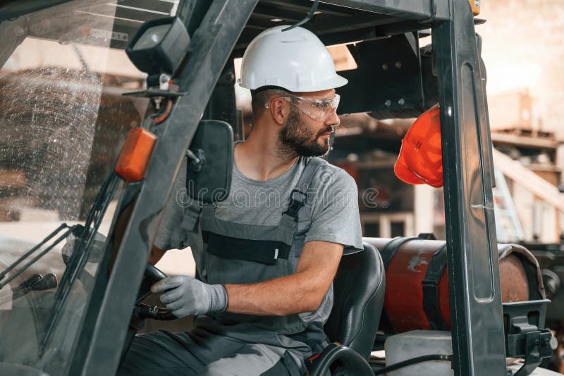 In the Forklift. Young Factory Worker in Grey Uniform Stock Photo ...