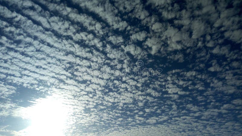 A Formation of White Clouds in the Form of Artistic Ripples in a Bright ...