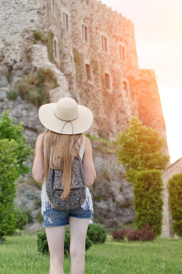 Fortress in the Distance. Girl in a Hat with a Backpackt. Back View ...