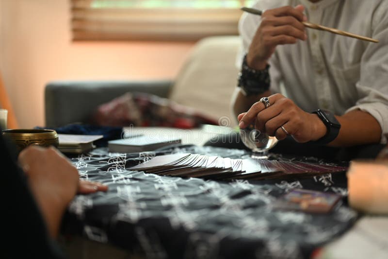 Fortune Teller during a Reading Session Talking To Client at Table with ...